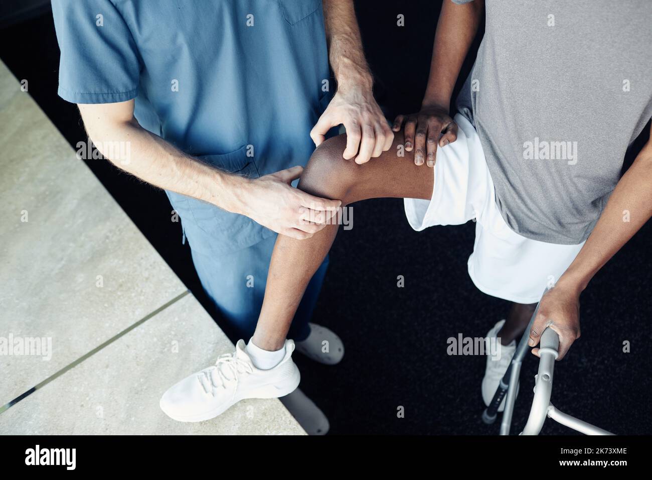 High angle view of doctor making massage of pain leg of athlete after ...