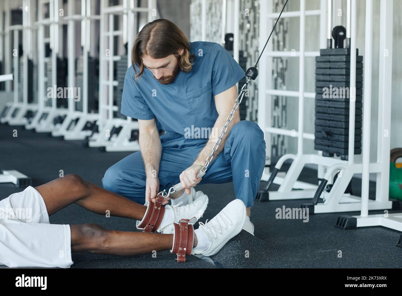 Doctor wearing sport equipment for stretching exercises to patient ...