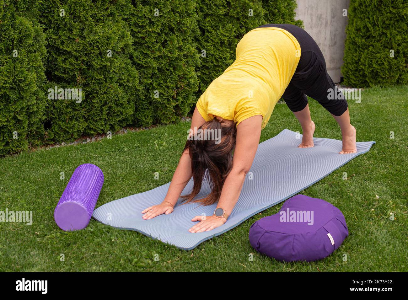 Woman learning to pratice yoga lying on a mat doing asanas for ...