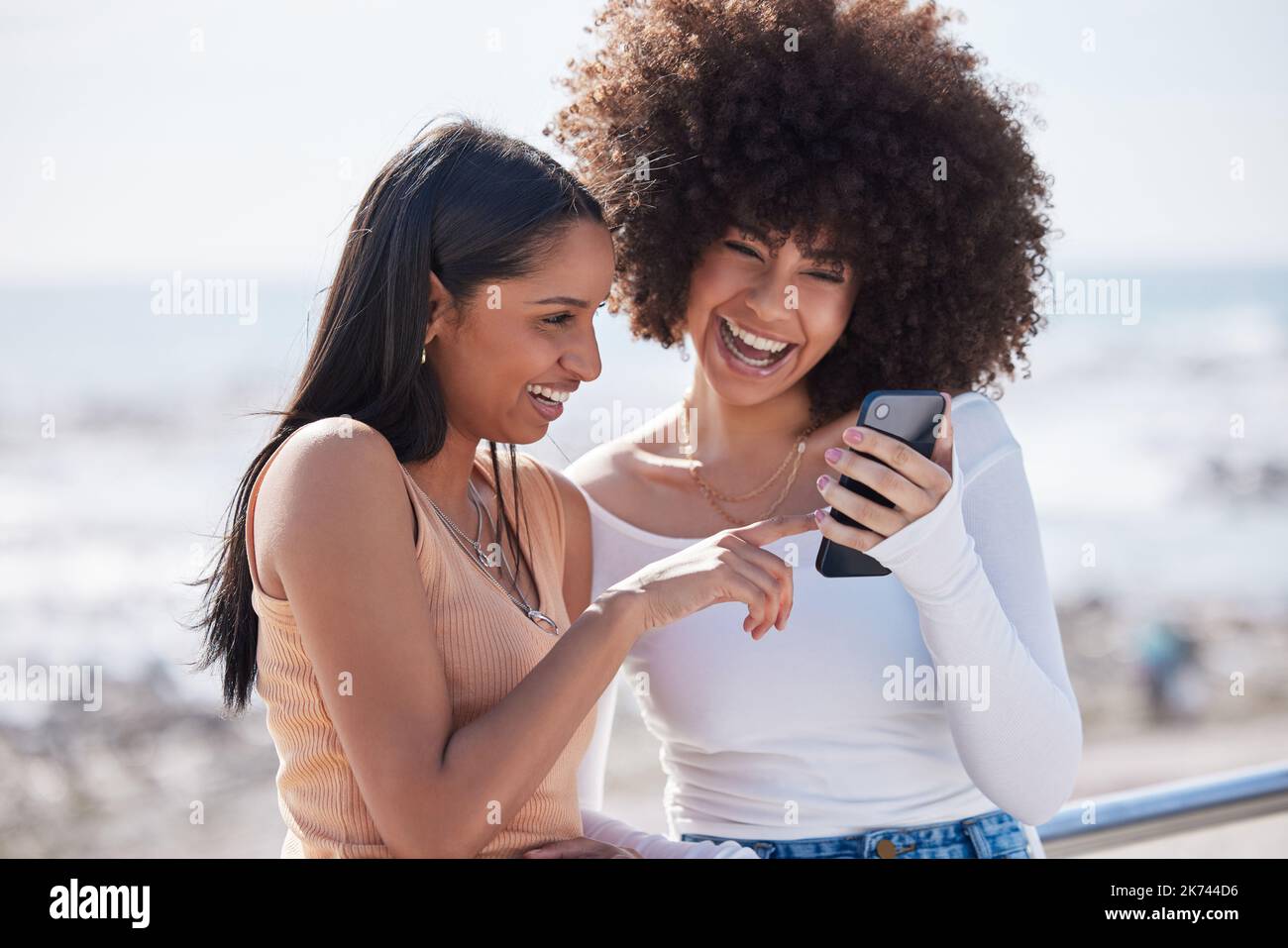 Best friends find the same memes funny. two young friends using a ...