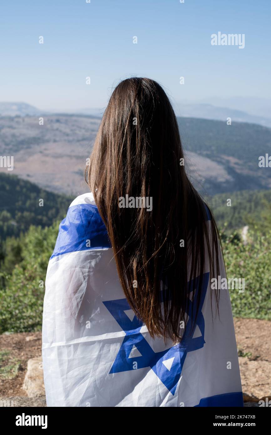 Teen female with Flag of Israel draped over her shoulders. Patriotic ...