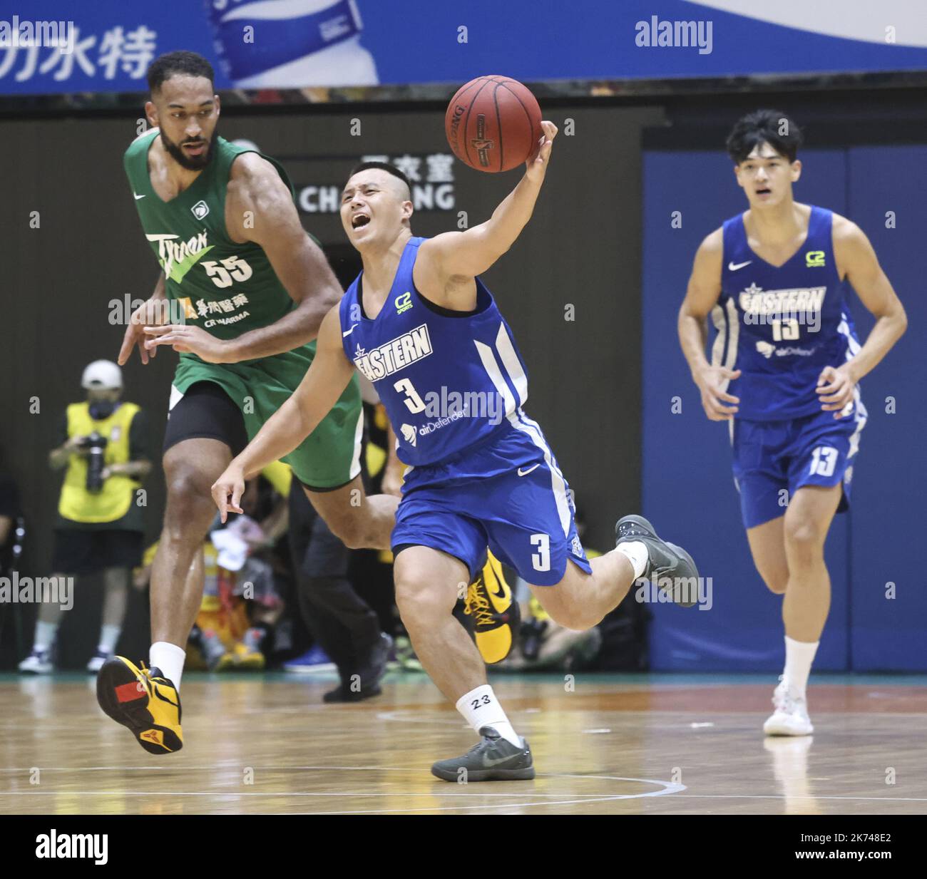 Eastern Long Lions Lee Ki (C) runs with the ball, pursued by Michael ...