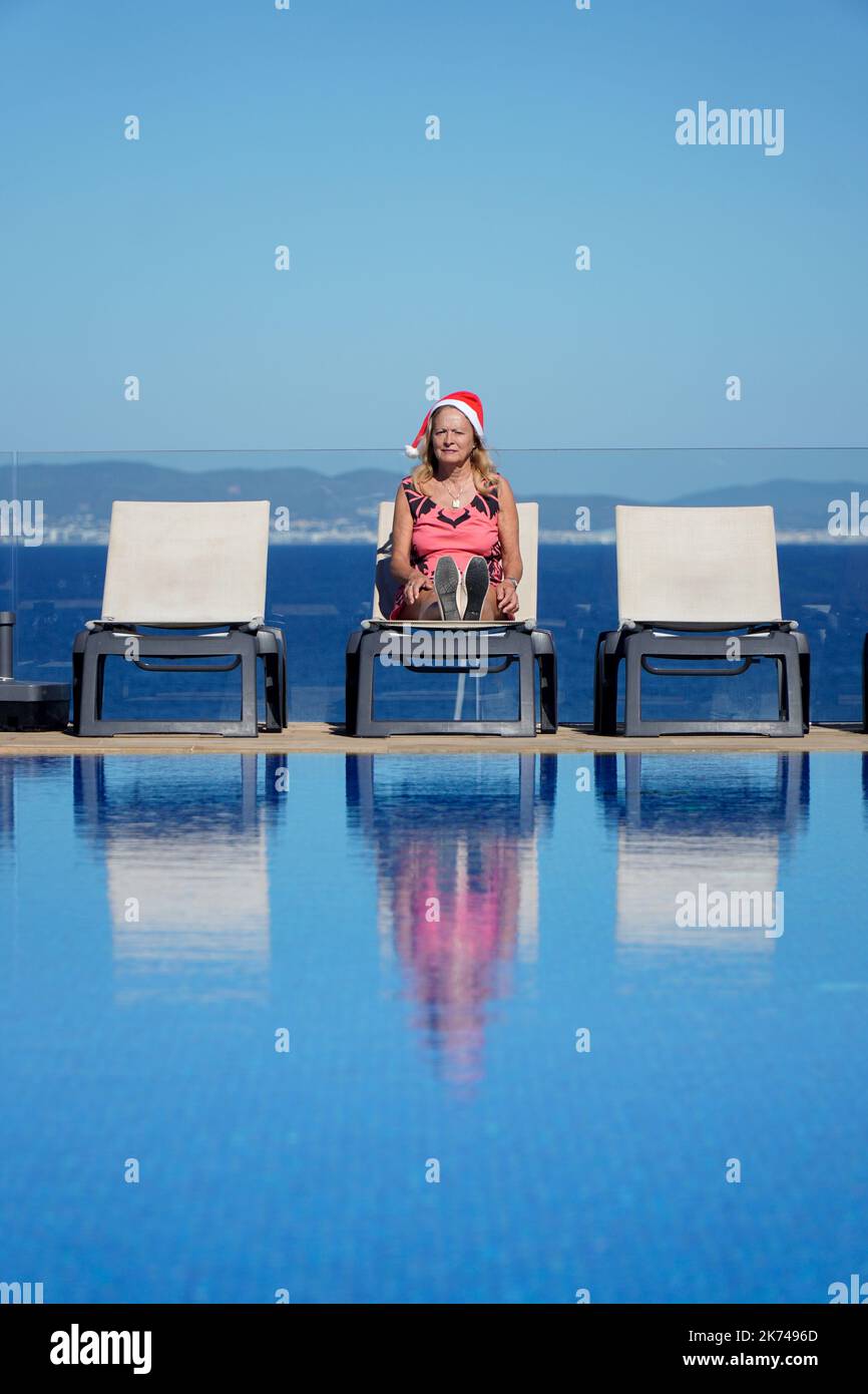Lady with christmas hat sitting in a hammock by the pool. Christmas ...