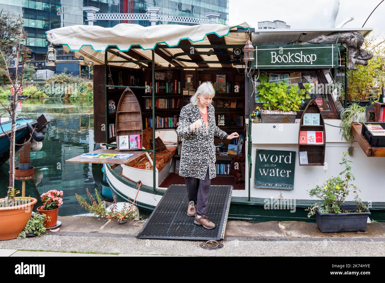 A woman exiting Word On The Water, aka The London Bookbarge, a floating ...
