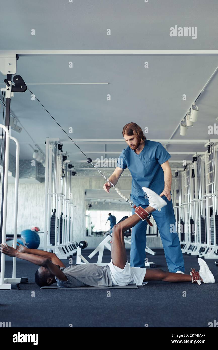 African patient doing physical exercises for recovery with the help of ...