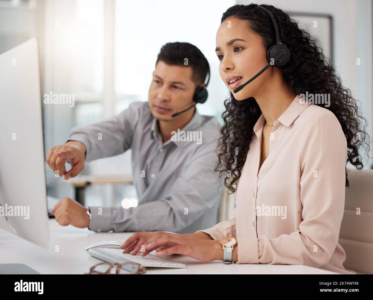 Understanding a few new processes. two call centre agents working ...