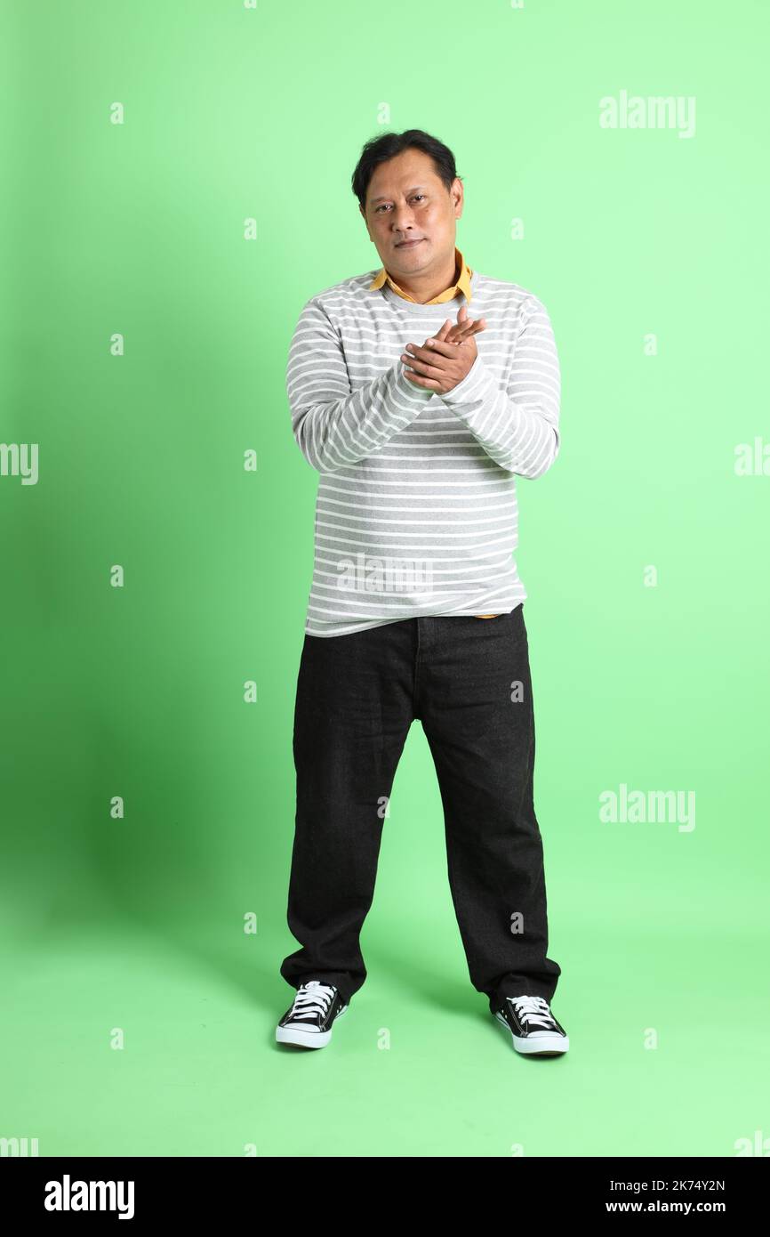 The 40s adult overweight Asian man standing on the green background ...
