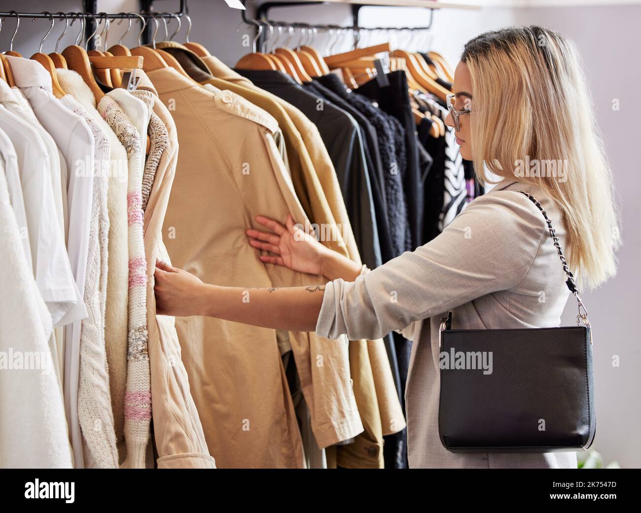 They have the best selection. a young woman browsing through clothing ...