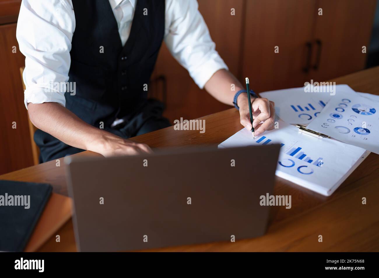 A portrait of a good-looking and discreet Asian man sitting at his desk ...