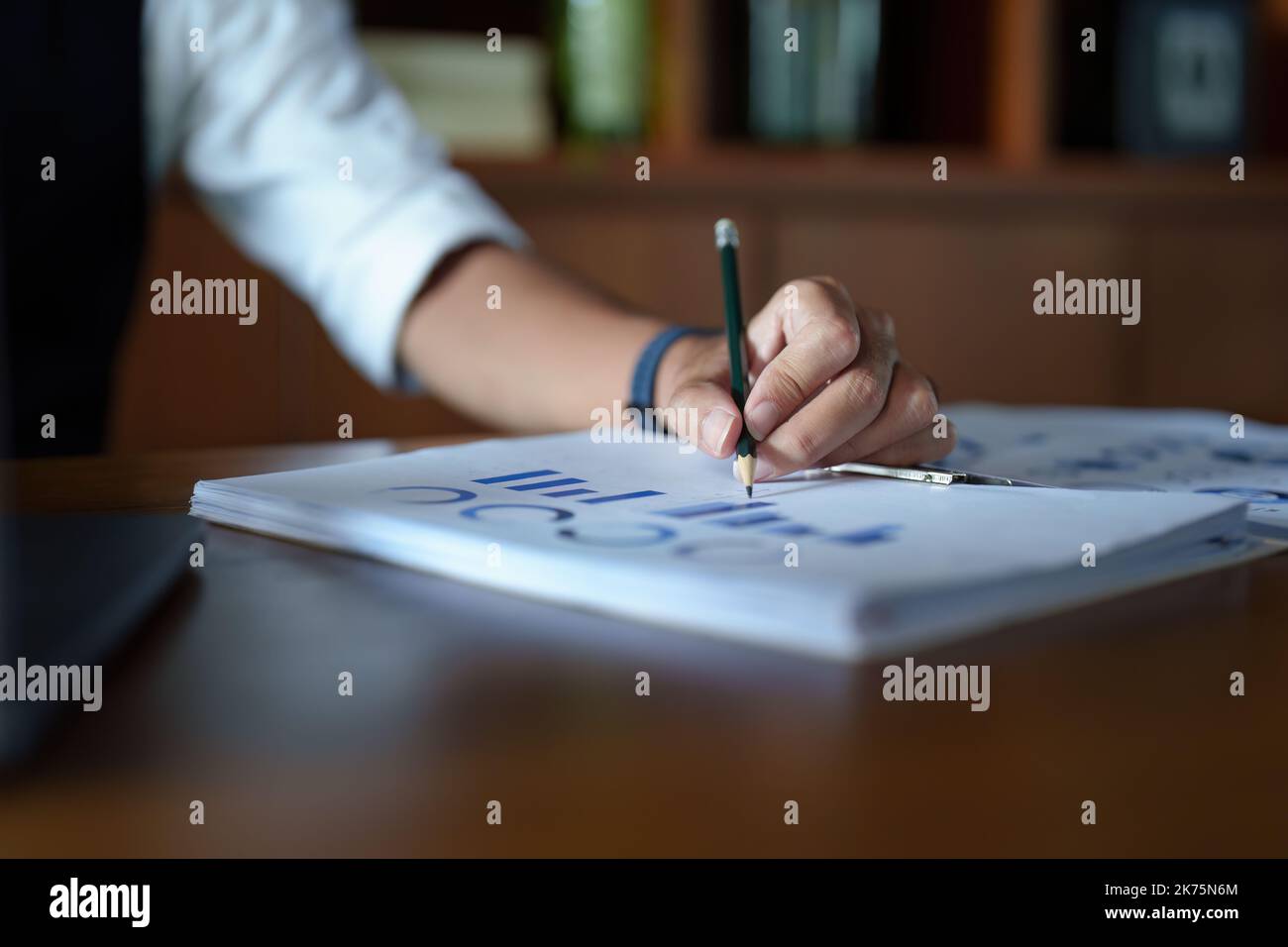 A portrait of a good-looking and discreet Asian man sitting at his desk ...