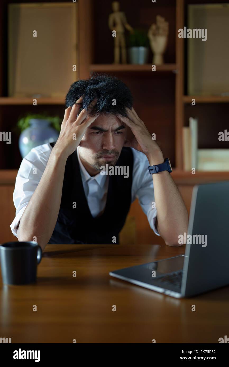 Portrait of an Asian man to be bored from working on a computer Stock ...