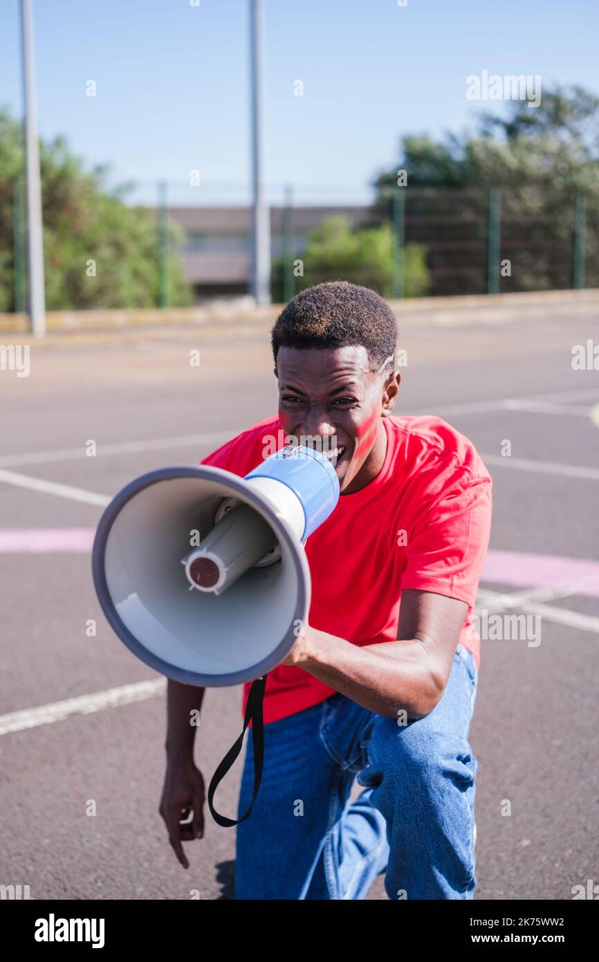 Young man with a megaphone throwing slogans with a brave attitude Stock ...