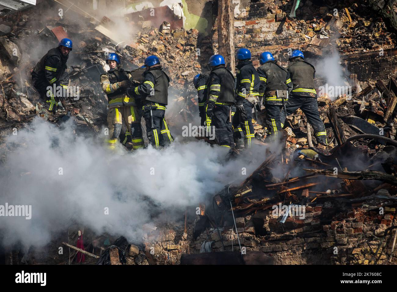Kyiv, Ukraine. 17th Oct, 2022. Ukrainian rescuers work at the site of a ...