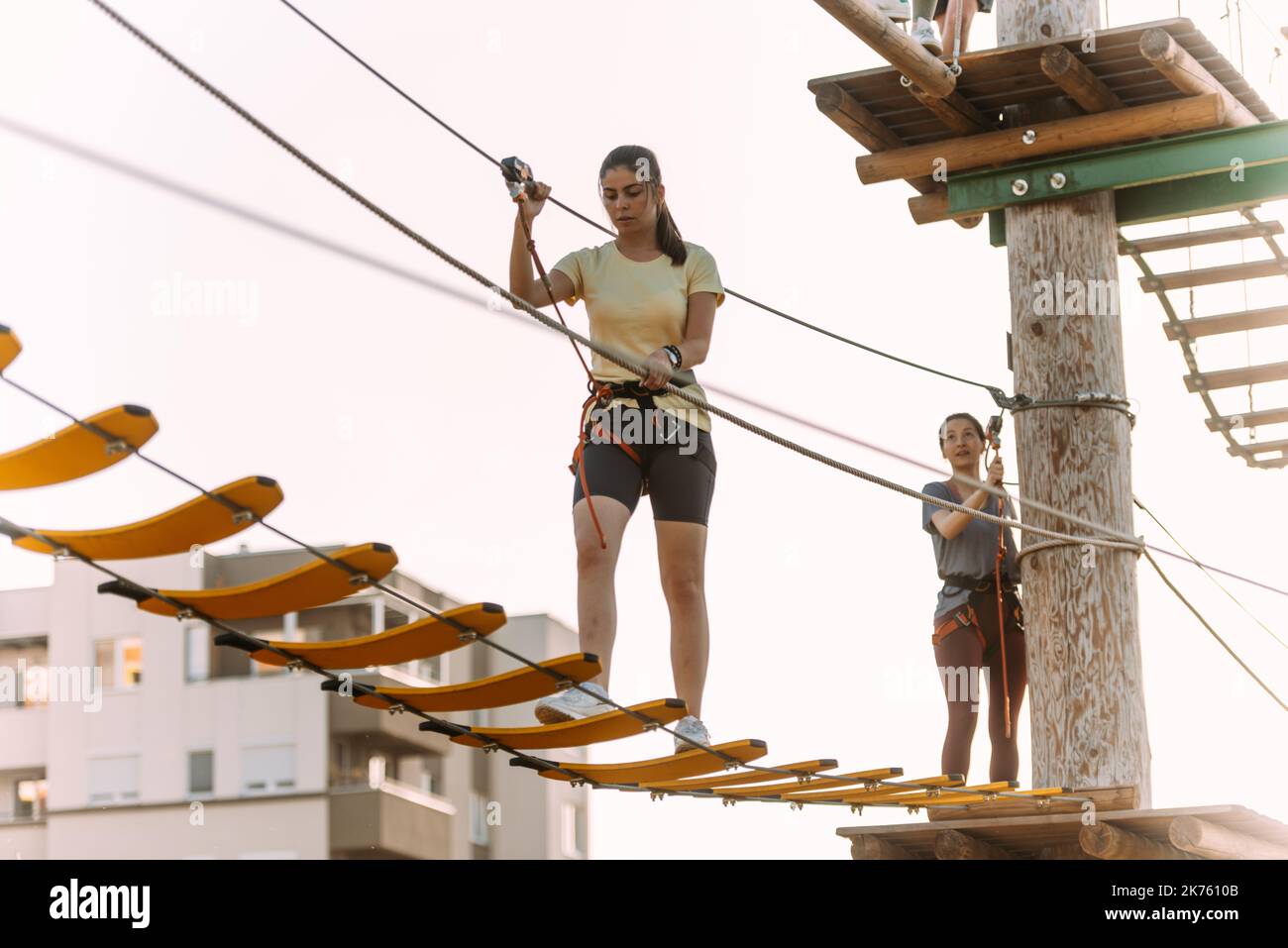 Group of rock climbers passing through the ladder obstacle in the ...