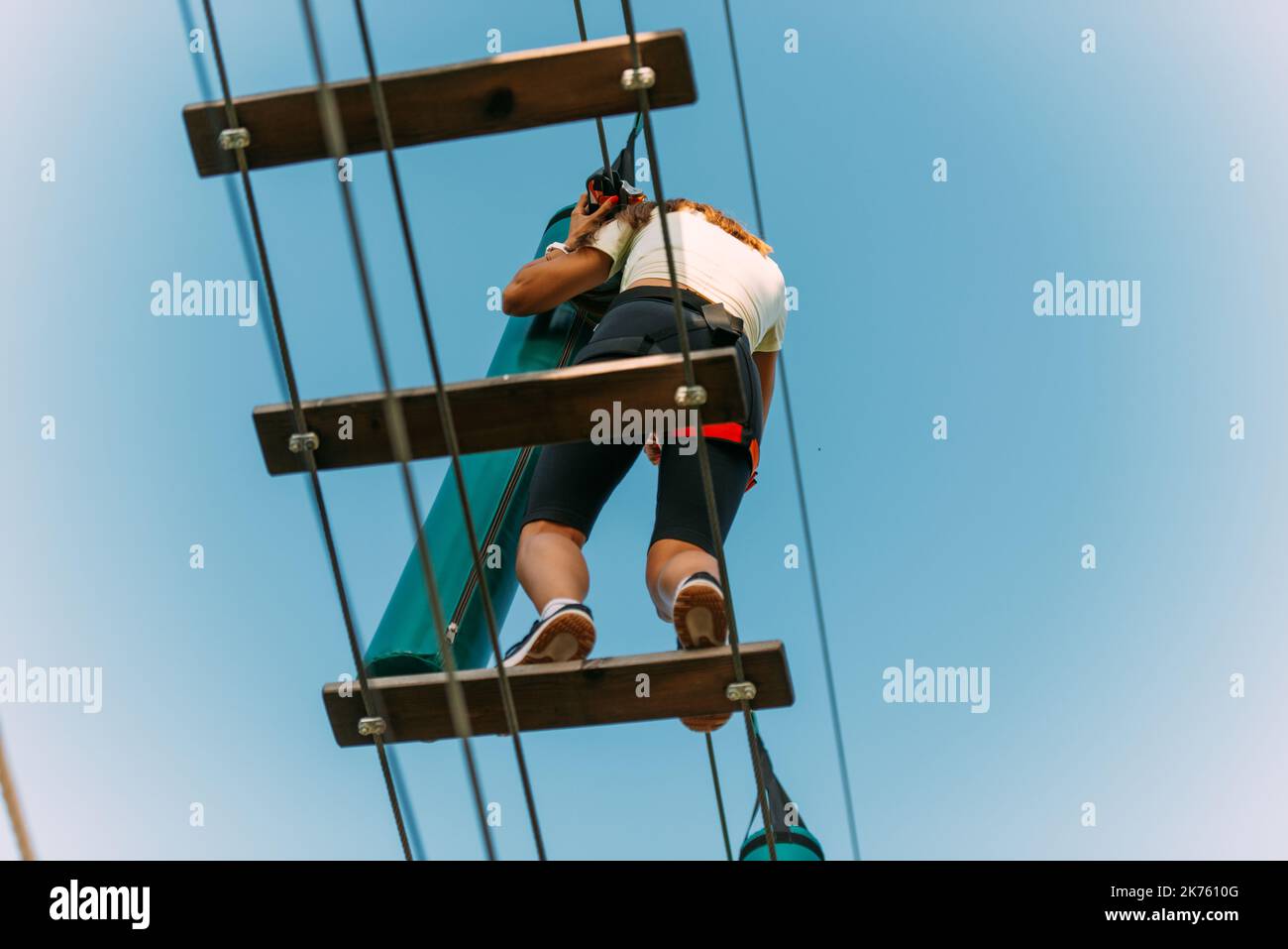Young professional climber clearing the ladder obstacle with ease in ...