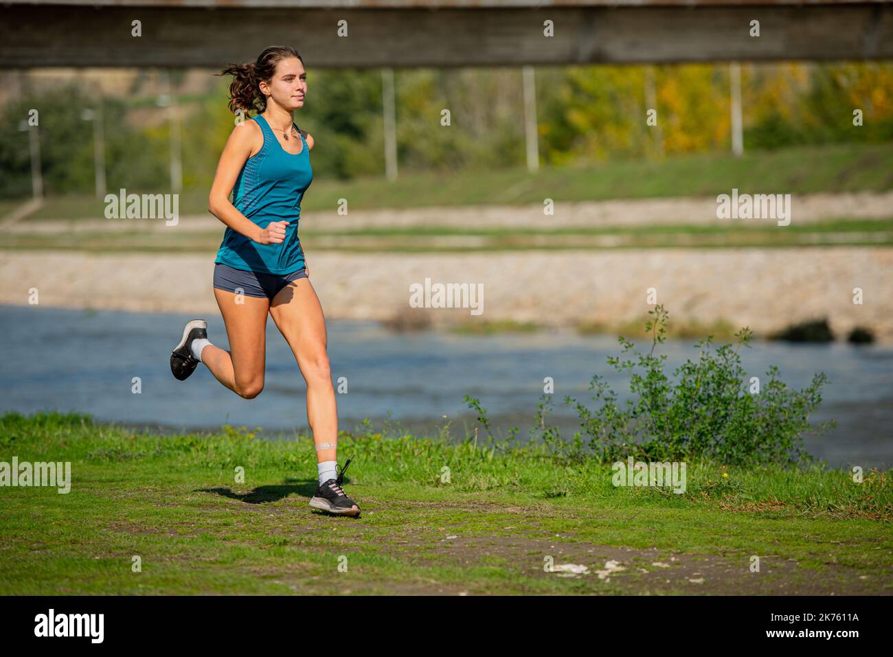 Attractive and beautiful fit girl is running slowly by the river Stock ...