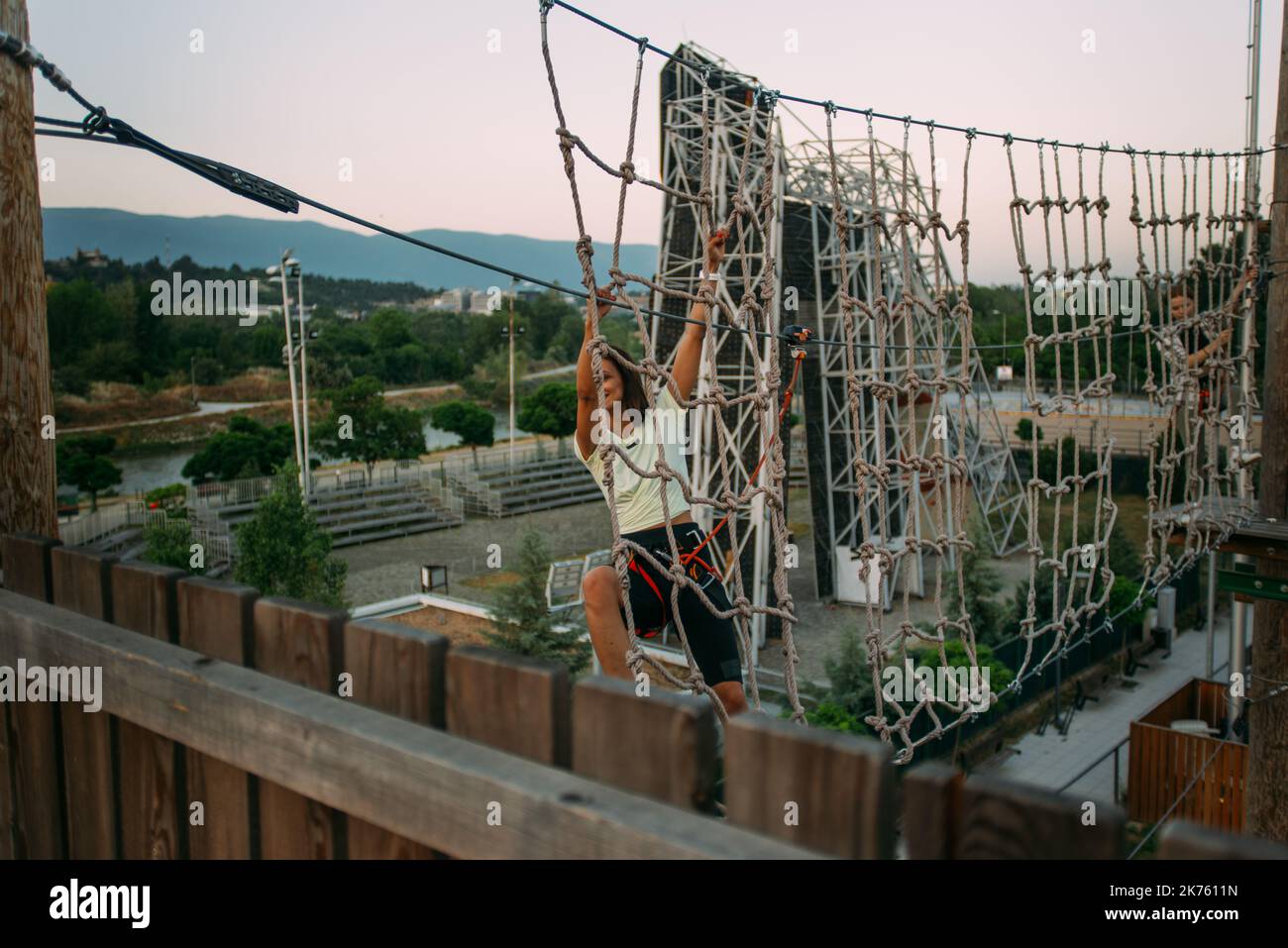 Two girls standing on the rope at the adventure park Stock Photo - Alamy