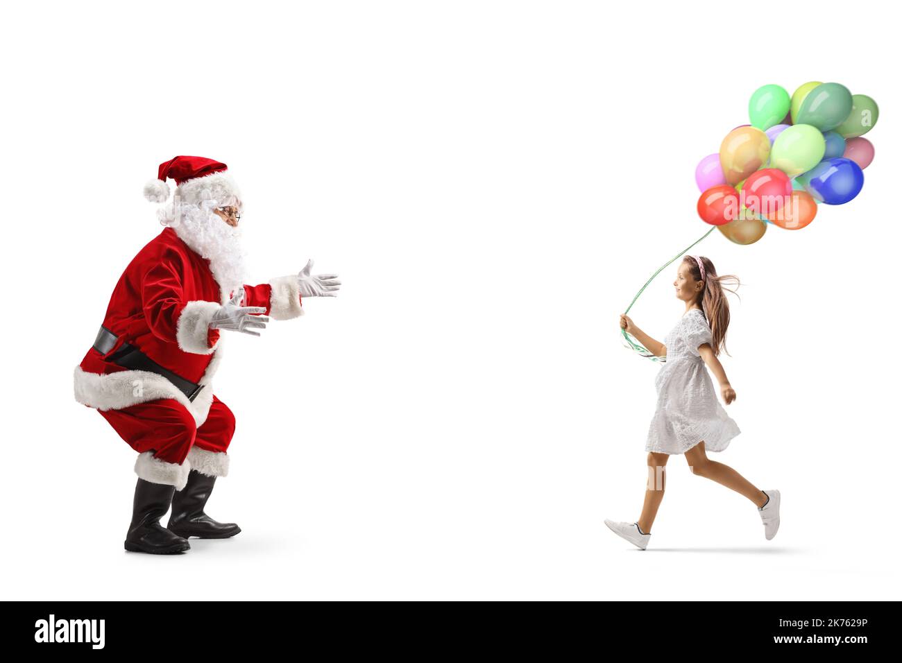 Full length profile shot of a girl with balloons running towards santa ...