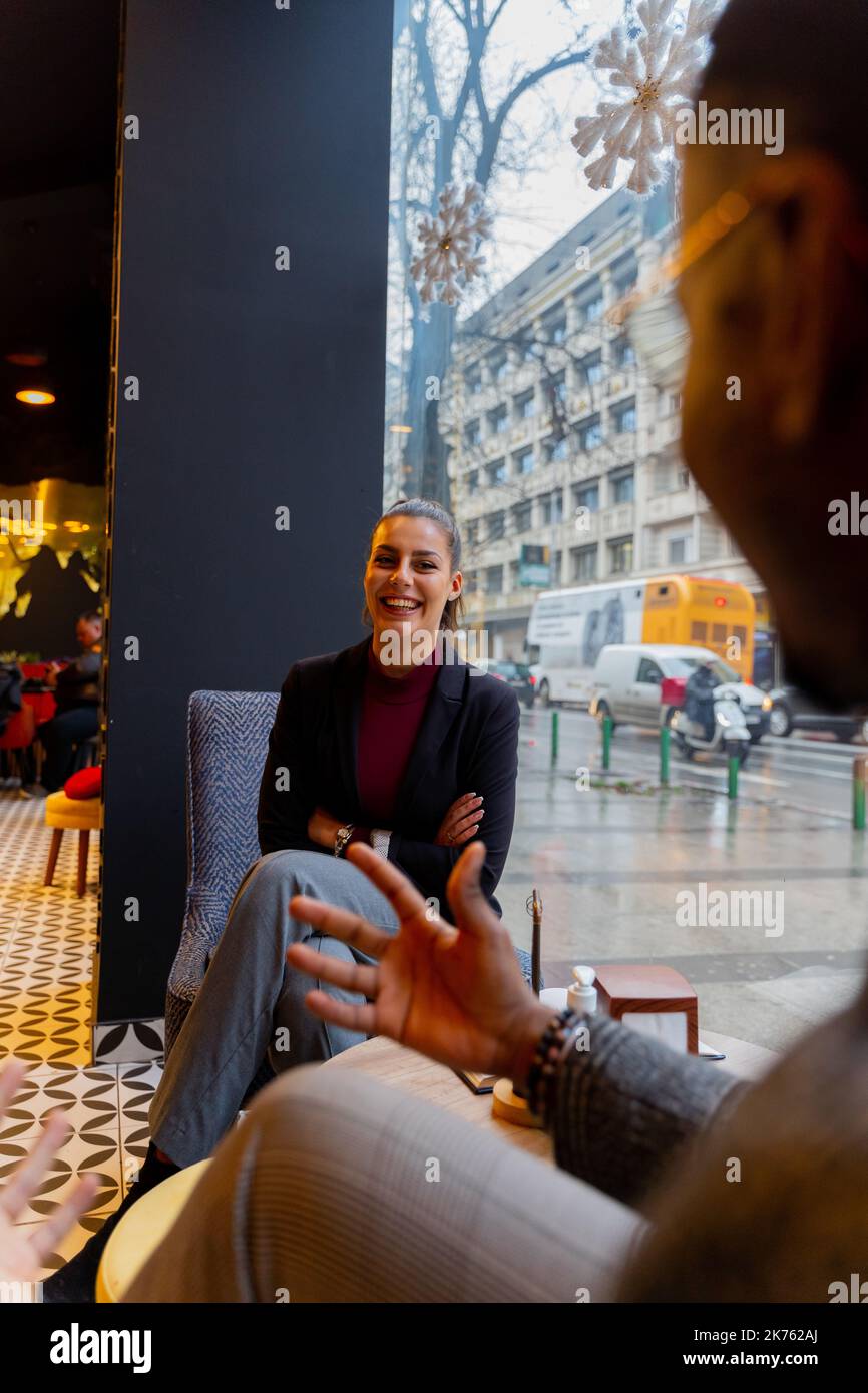 Two multiracial business partners are smiling and talking Stock Photo ...