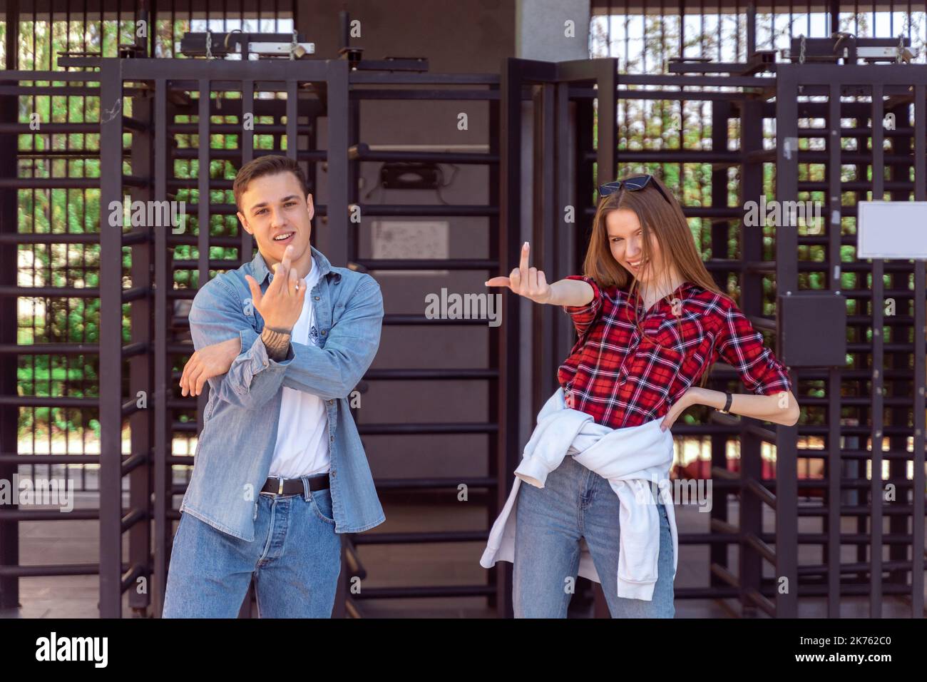 Cute couple pointing the middle finger at the camera while standing ...