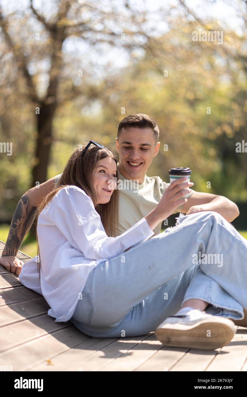 Two smiling friends talking to each other while enjoying in beautiful ...
