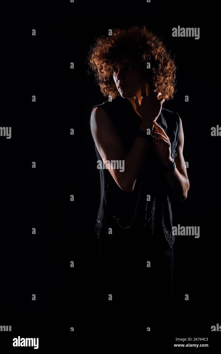 Cool young man dressed in black jeans vest, black jeans and sneakers ...