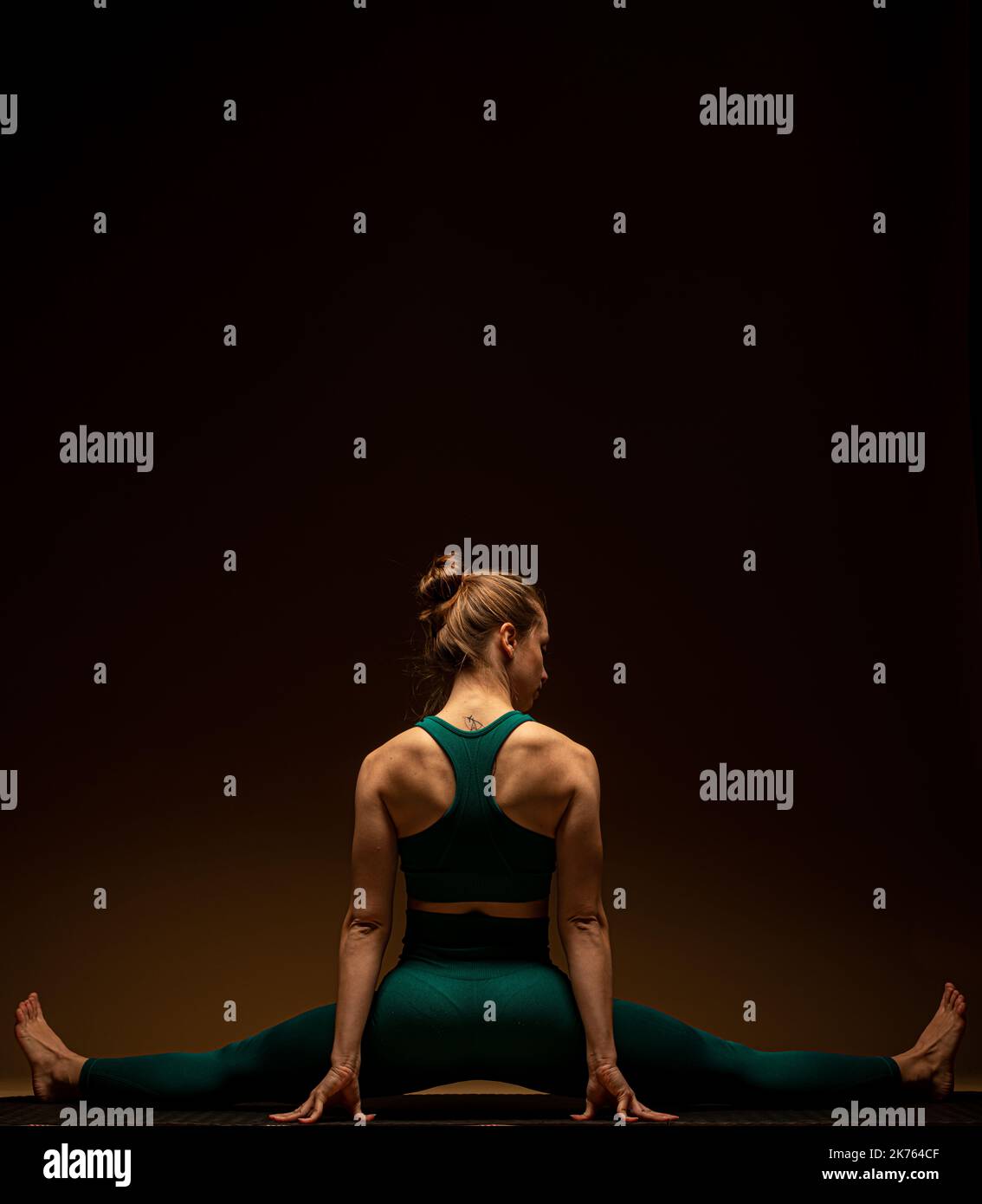 Attractive and beautiful young girl is doing splits on the ground and ...