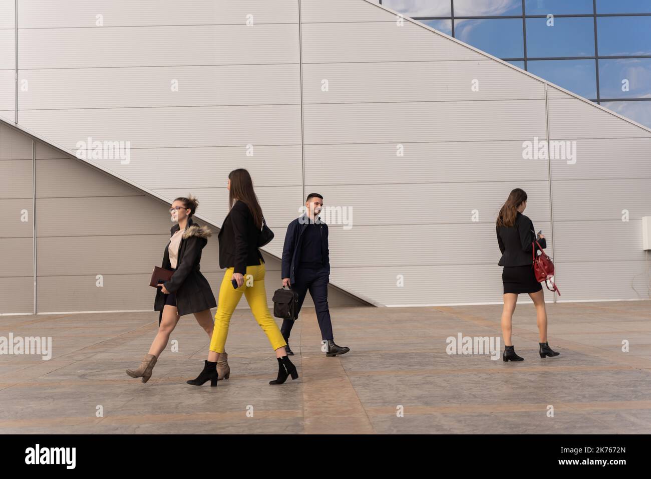 Group of young business people are walking fast all together while ...