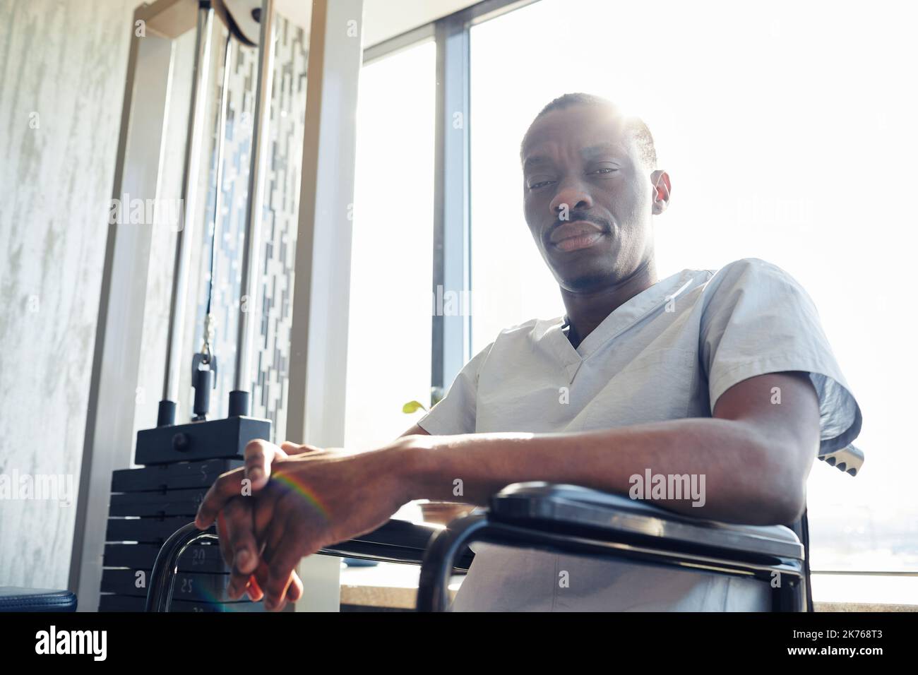 Portrait of African patient with disability sitting in wheelchair and ...