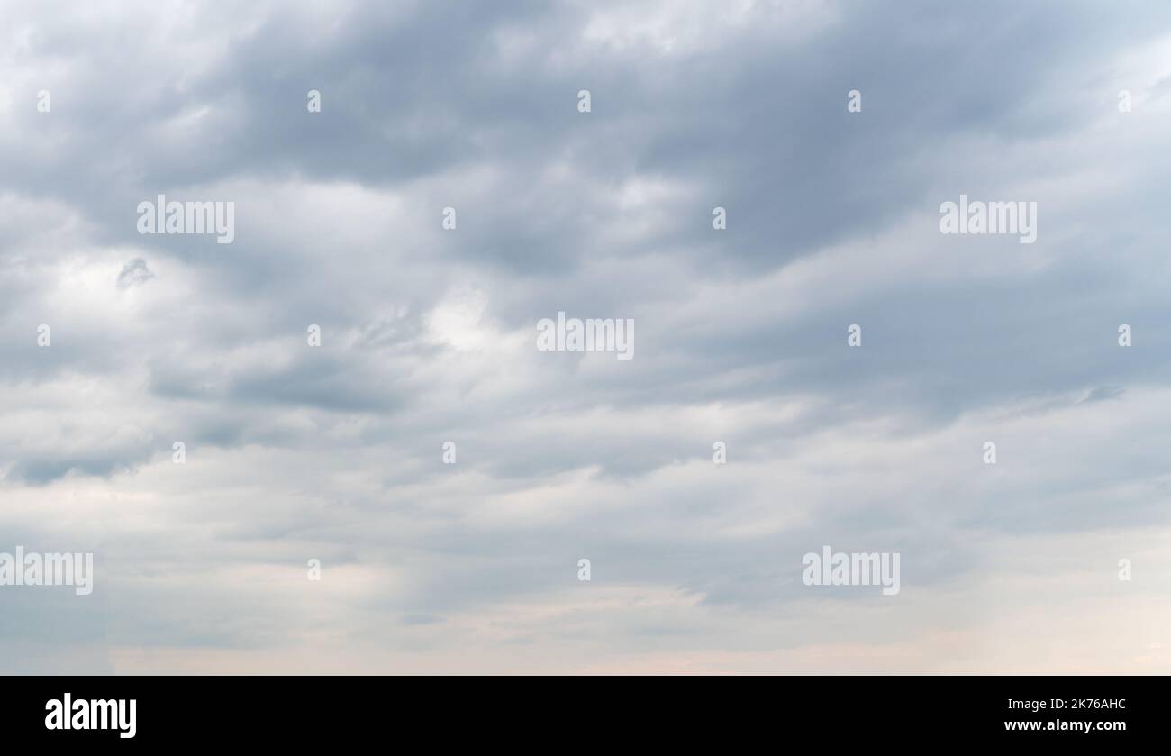Smooth rows of gray clouds block out the sunlight Stock Photo - Alamy