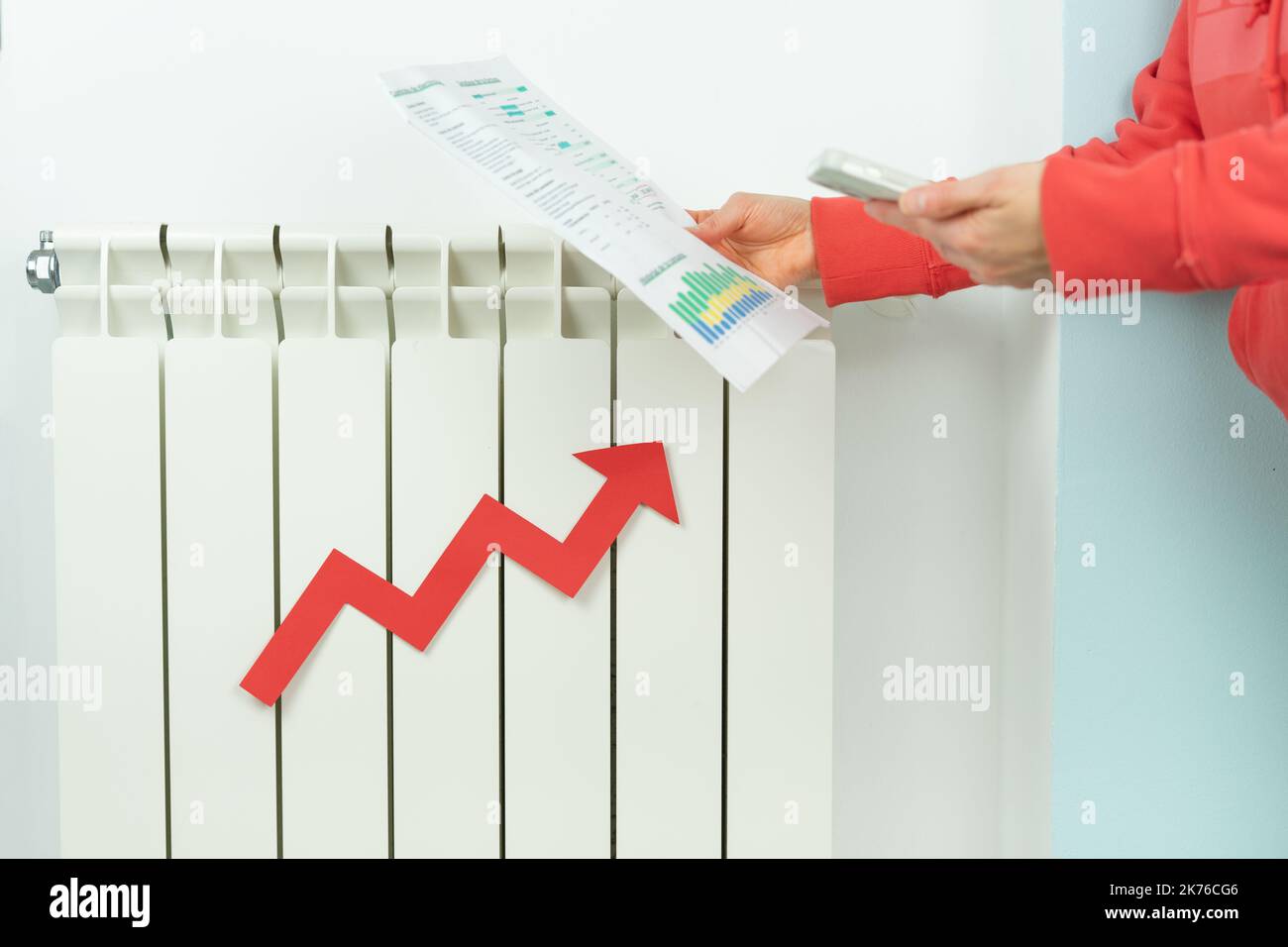 Woman's hands with electricity bill closing heating radiator with red ...