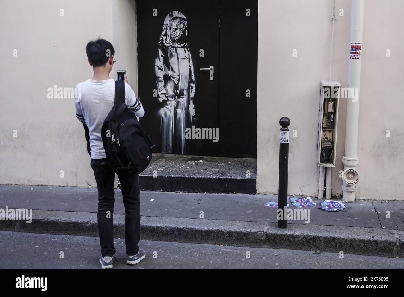 A man takes a photograph of a recent artwork by street artist Banksy in ...