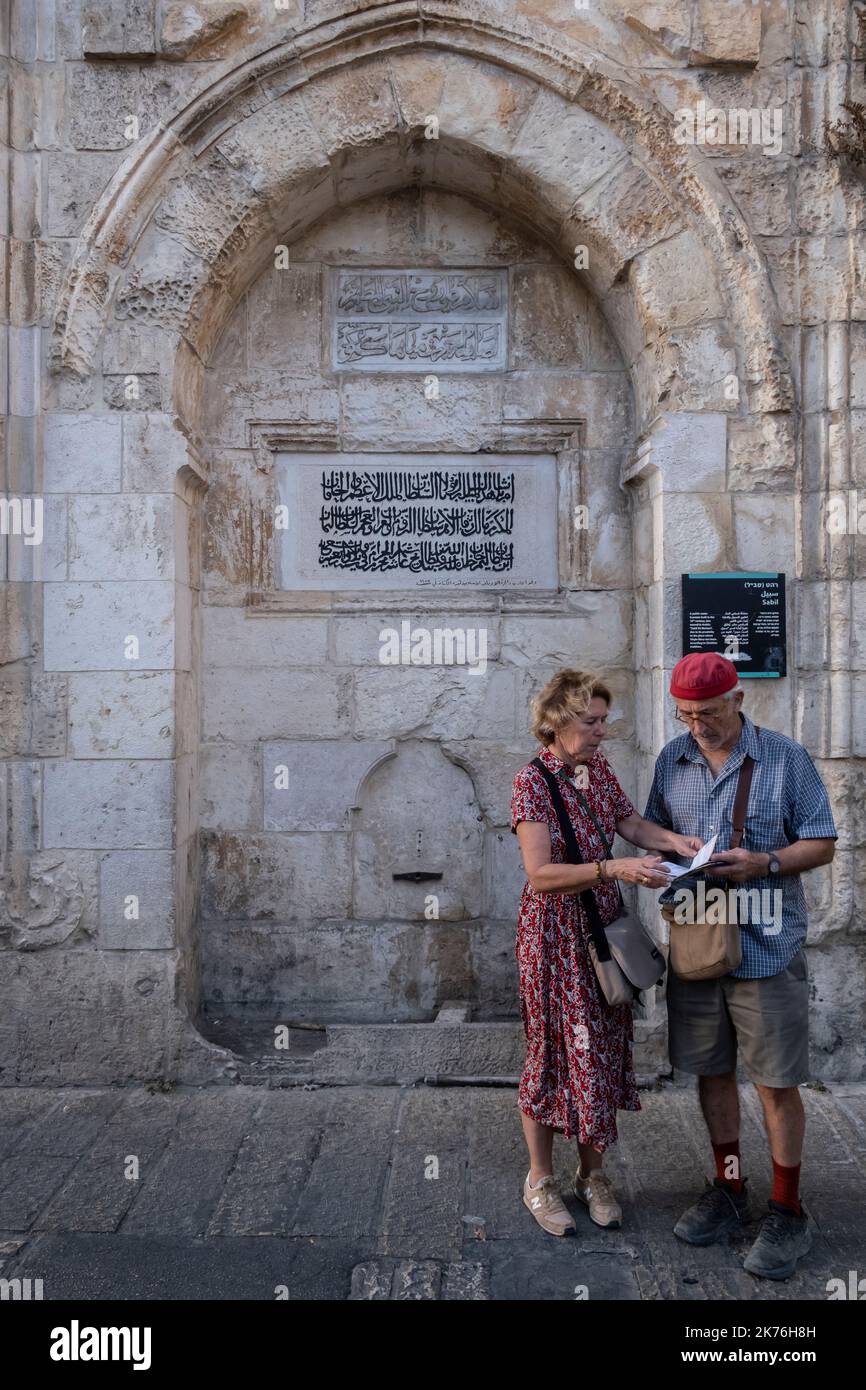 Tourists stand in front of a Sabil water fountain to provide drinking ...