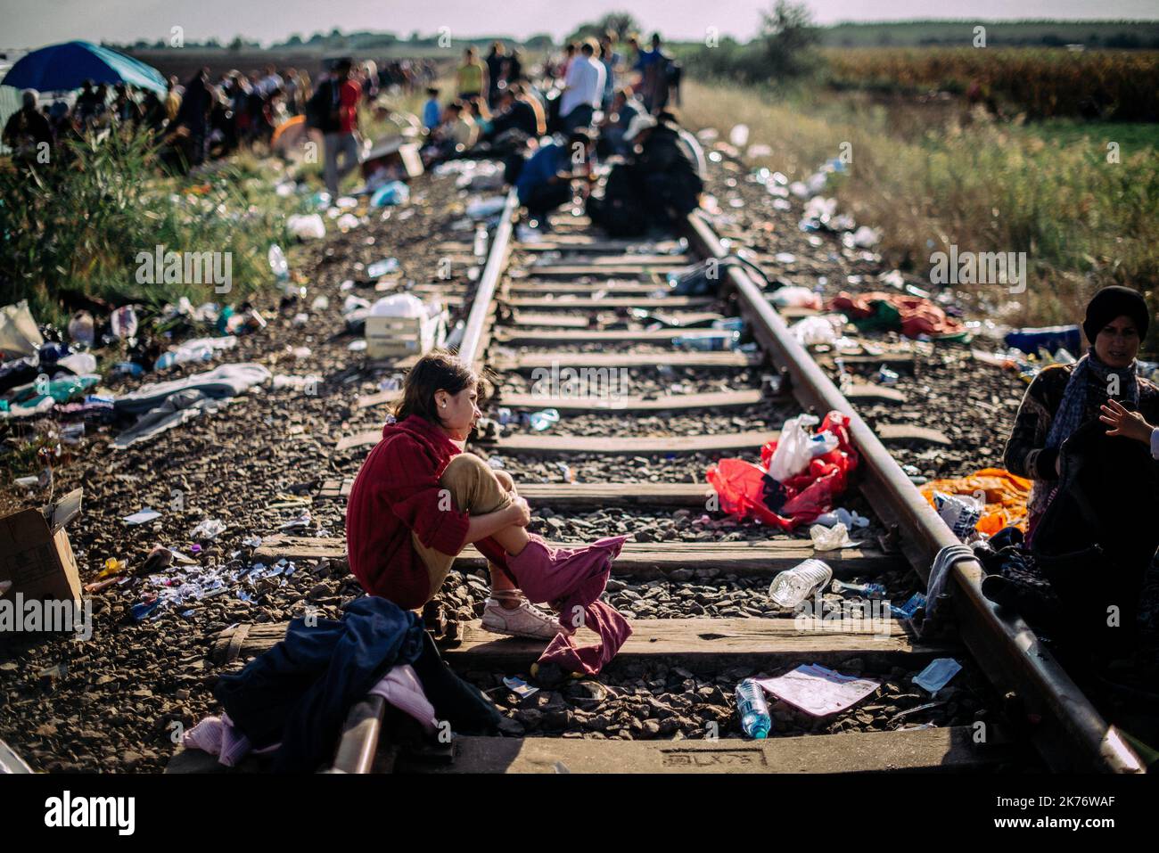 Refugees wait to be put on buses to go to camps in Roszke, the Serbian ...