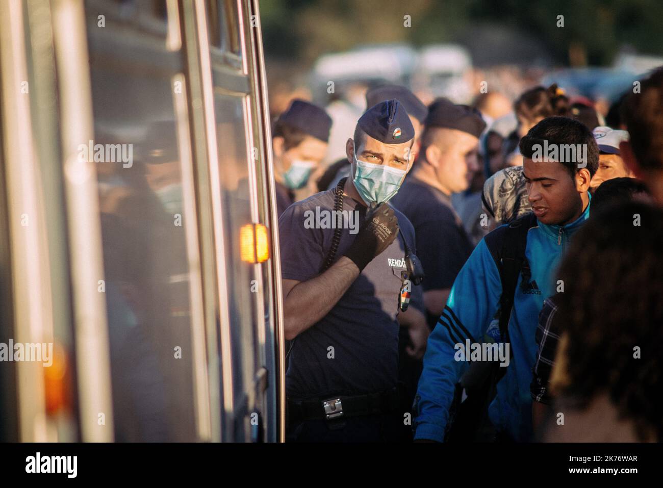 A Hungarian policeman takes refugees on buses to camps in Roszke, the ...