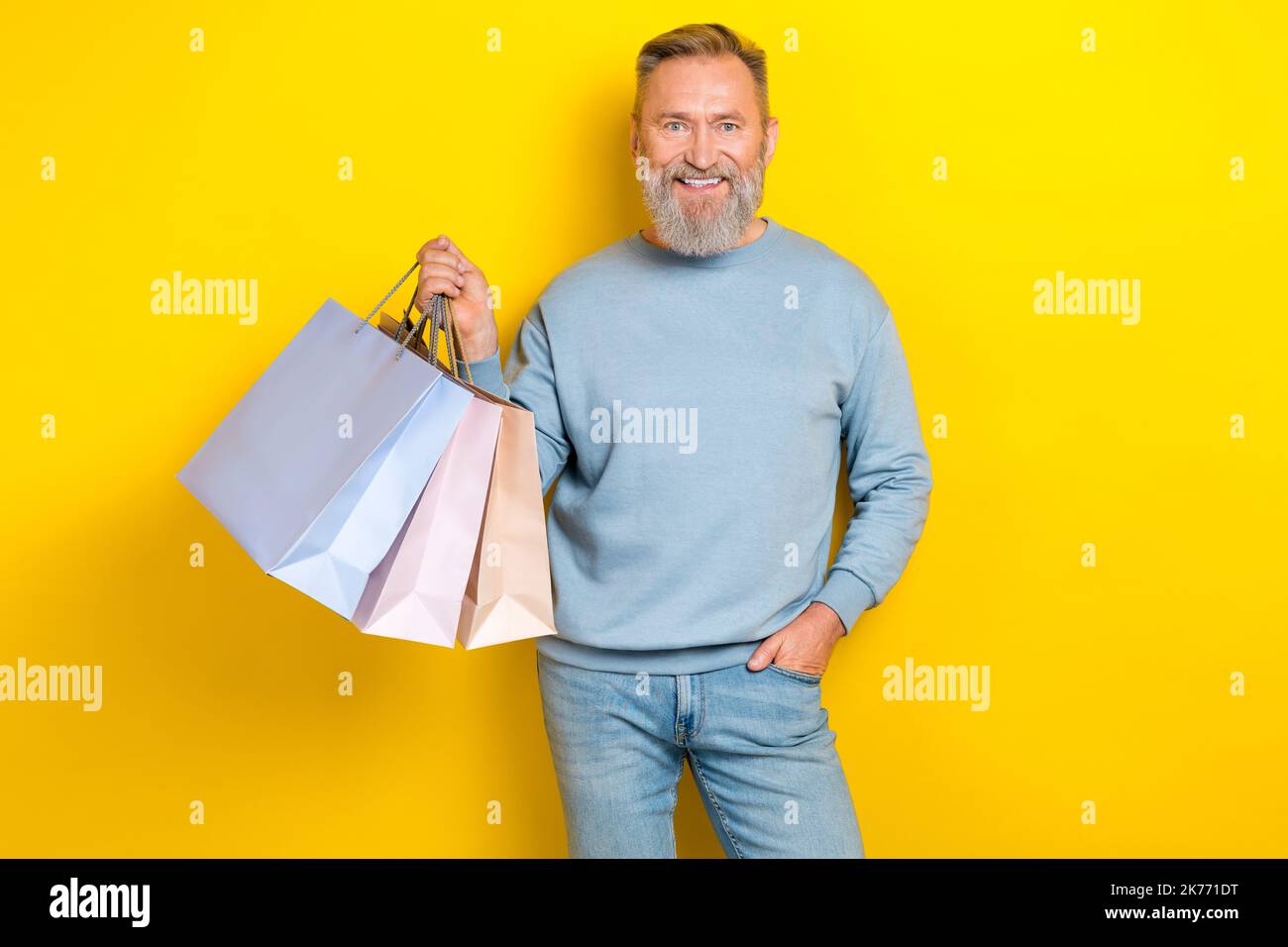Photo of cheerful aged person arm hold boutique bags toothy smile ...
