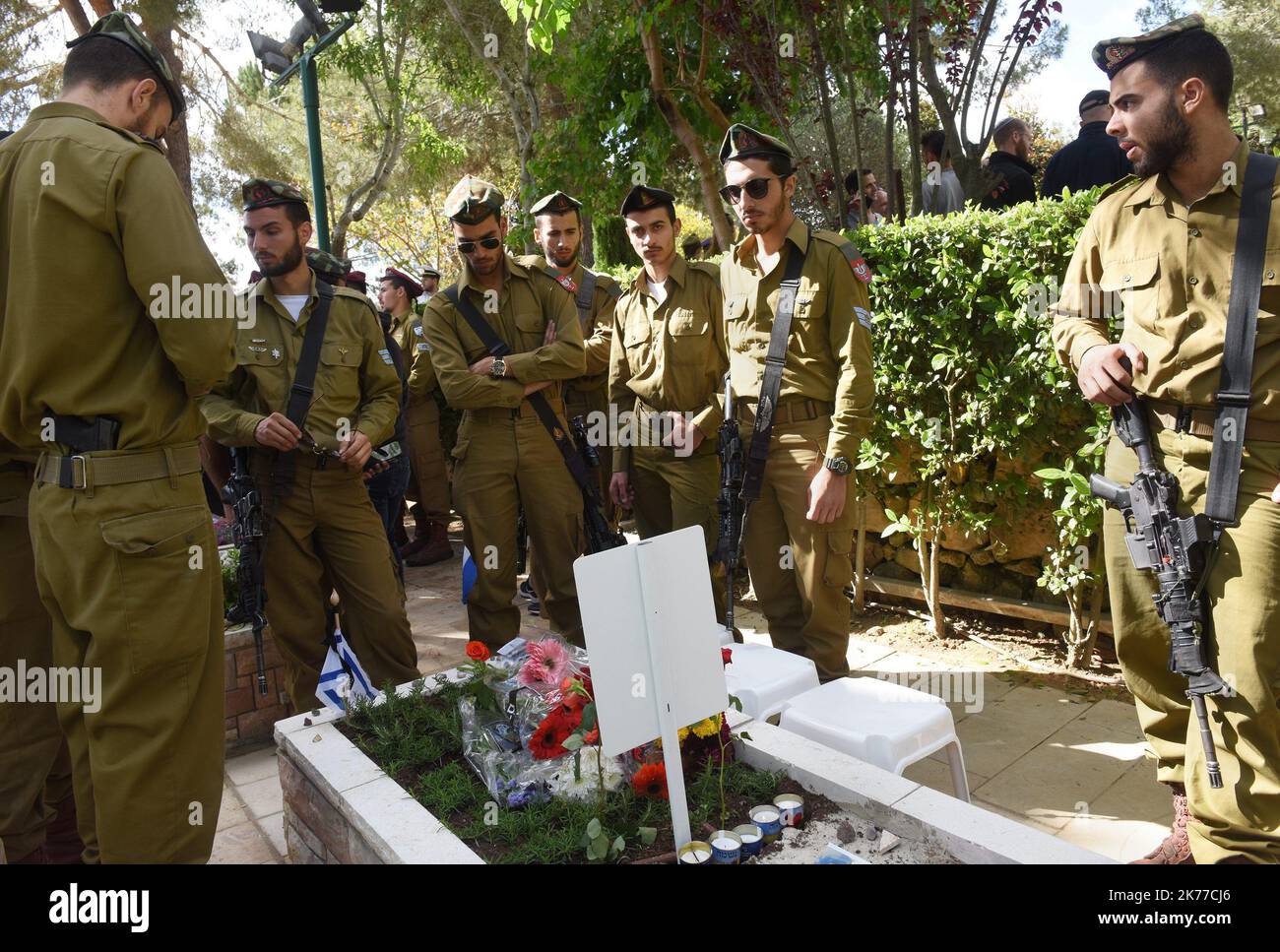 An Israeli soldier sits by the graves of fallen soldiers in the Mt ...