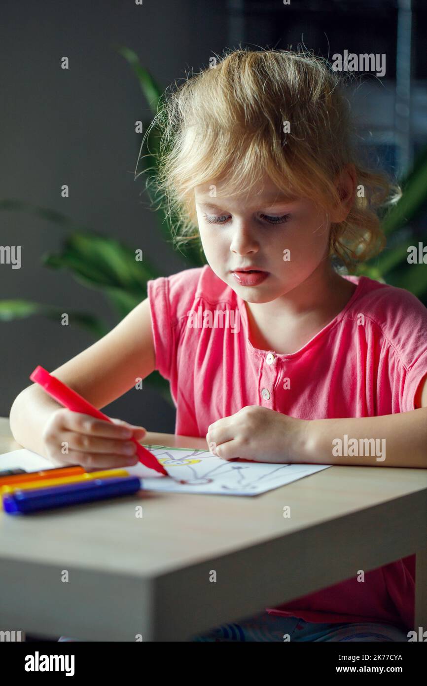 Little girl drawing a picture with colored markers. Child, sitting at ...
