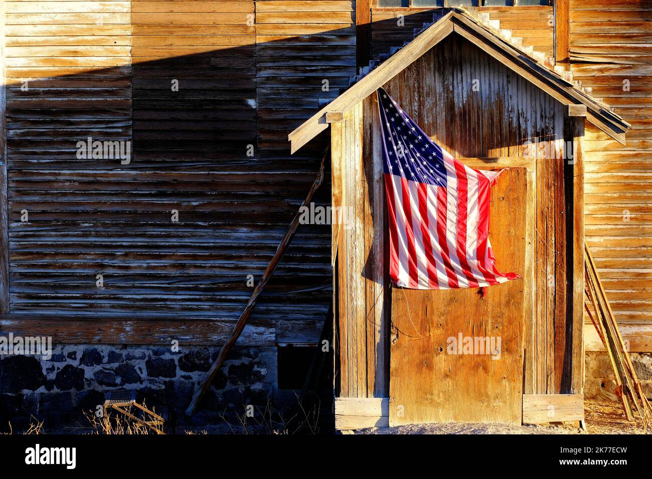 Old American flag on weathered building wooden door Stock Photo - Alamy