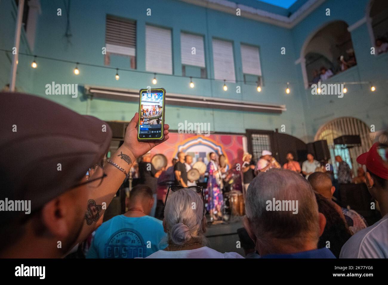 Audience member recording Bomba and Plena performance on smartphone at ...