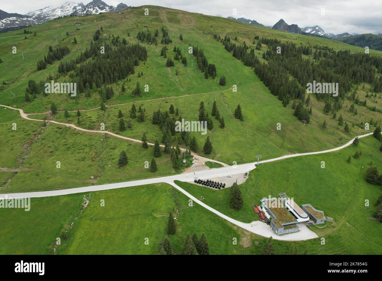 An aerial of a mountain village landscape with grass and trees, cloudy ...