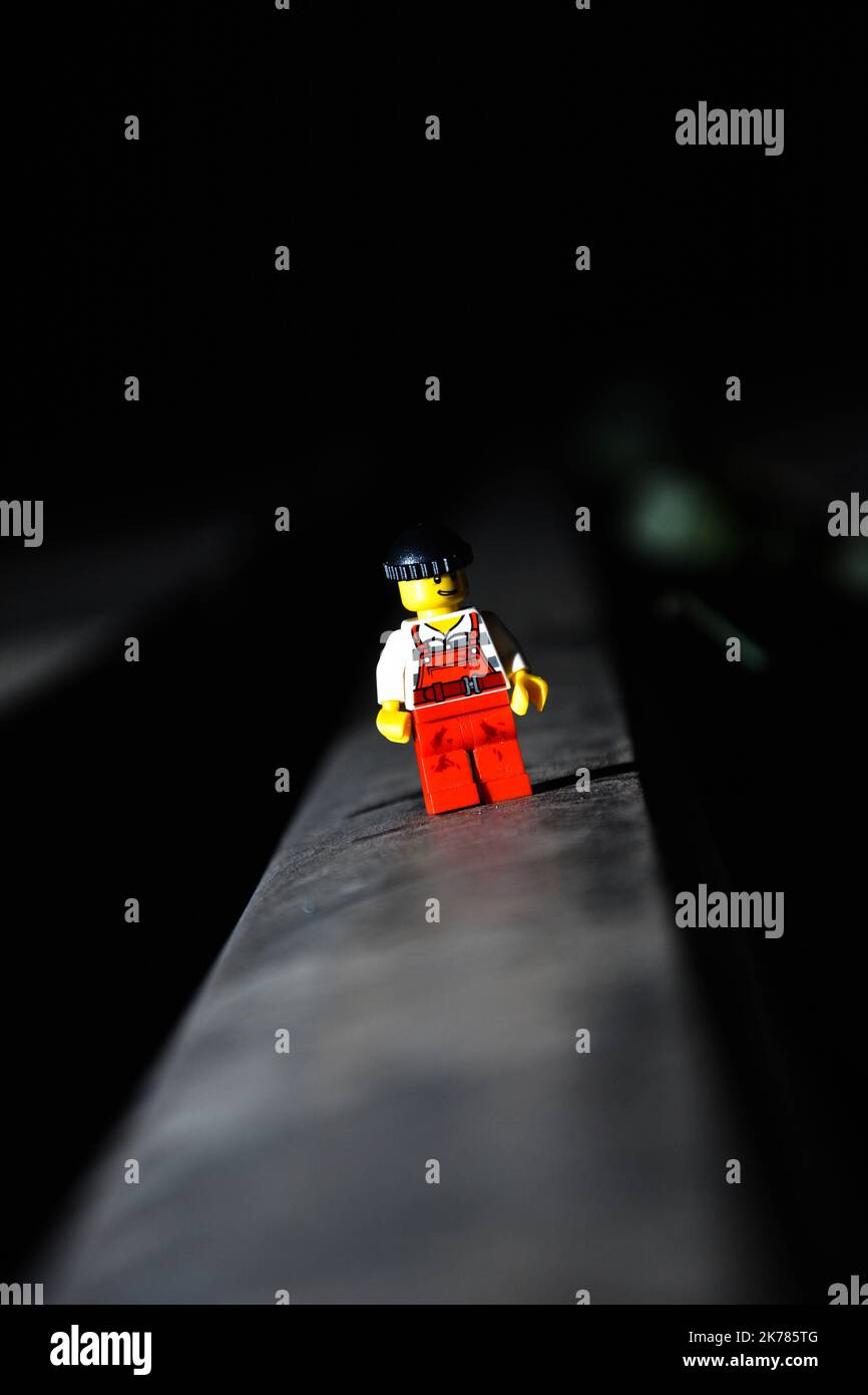 A vertical closeup Lego movie hero standing on a black surface with ...