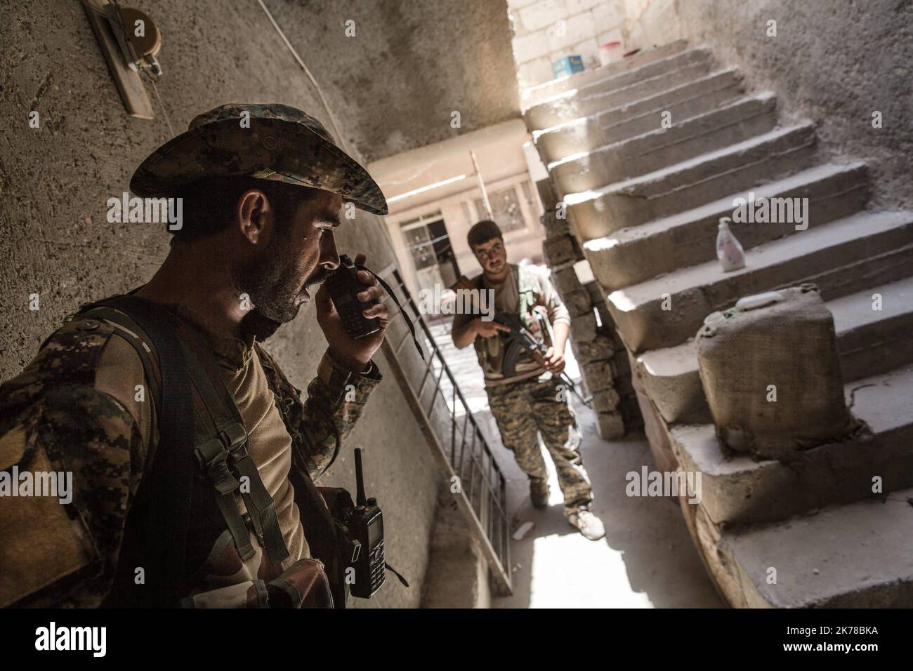 An arab fighter of the SDF is calling his commander to check the safety ...