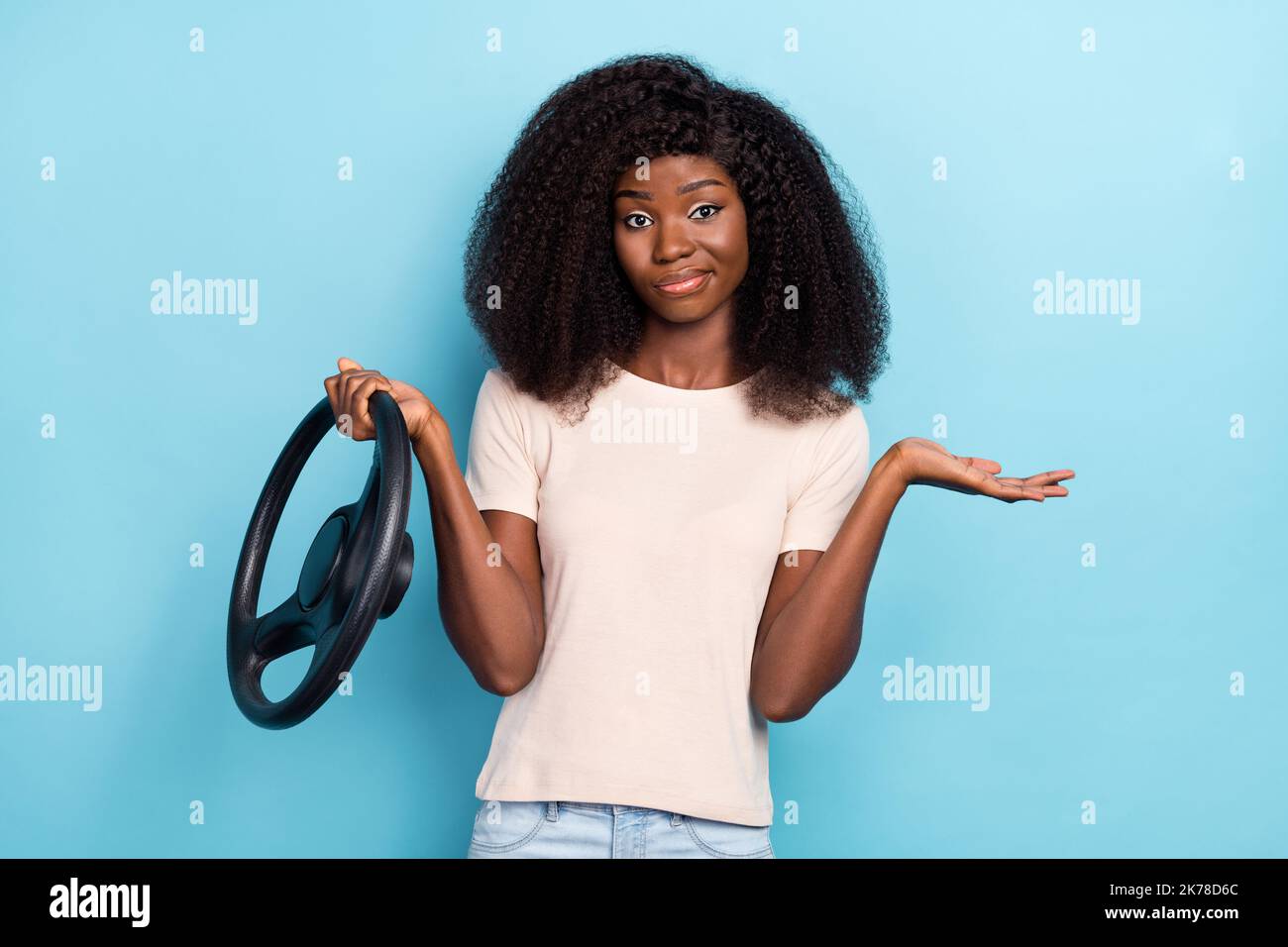 Portrait of clueless young lady hand hold wheel shrug shoulders ...