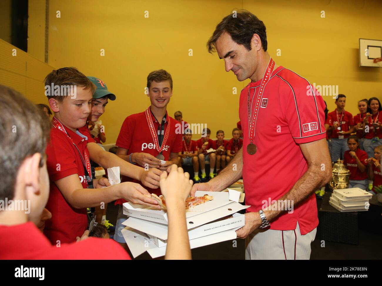 Switzerland's Roger Federer eats pizza with ball kids after defeating Australia's Alex De Minaur ...
