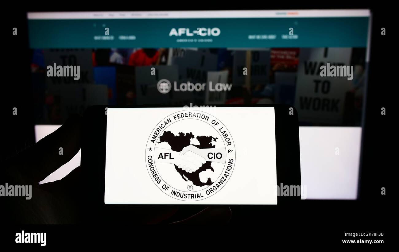 Person holding cellphone with logo of US union federation AFL-CIO on ...
