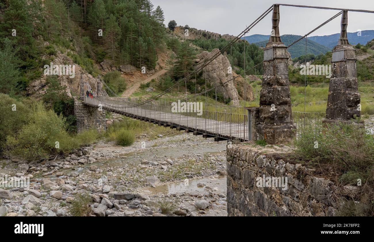 a stone pier, cable stay suspension foot bridge over a mountain river ...