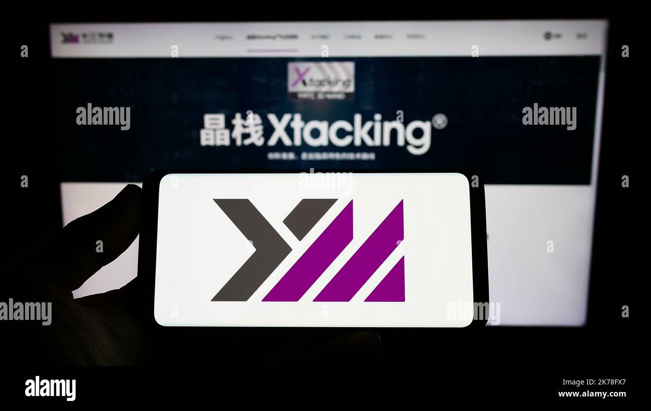Person holding smartphone with logo of company Yangtze Memory Technologies Corp. (YMTC) on ...