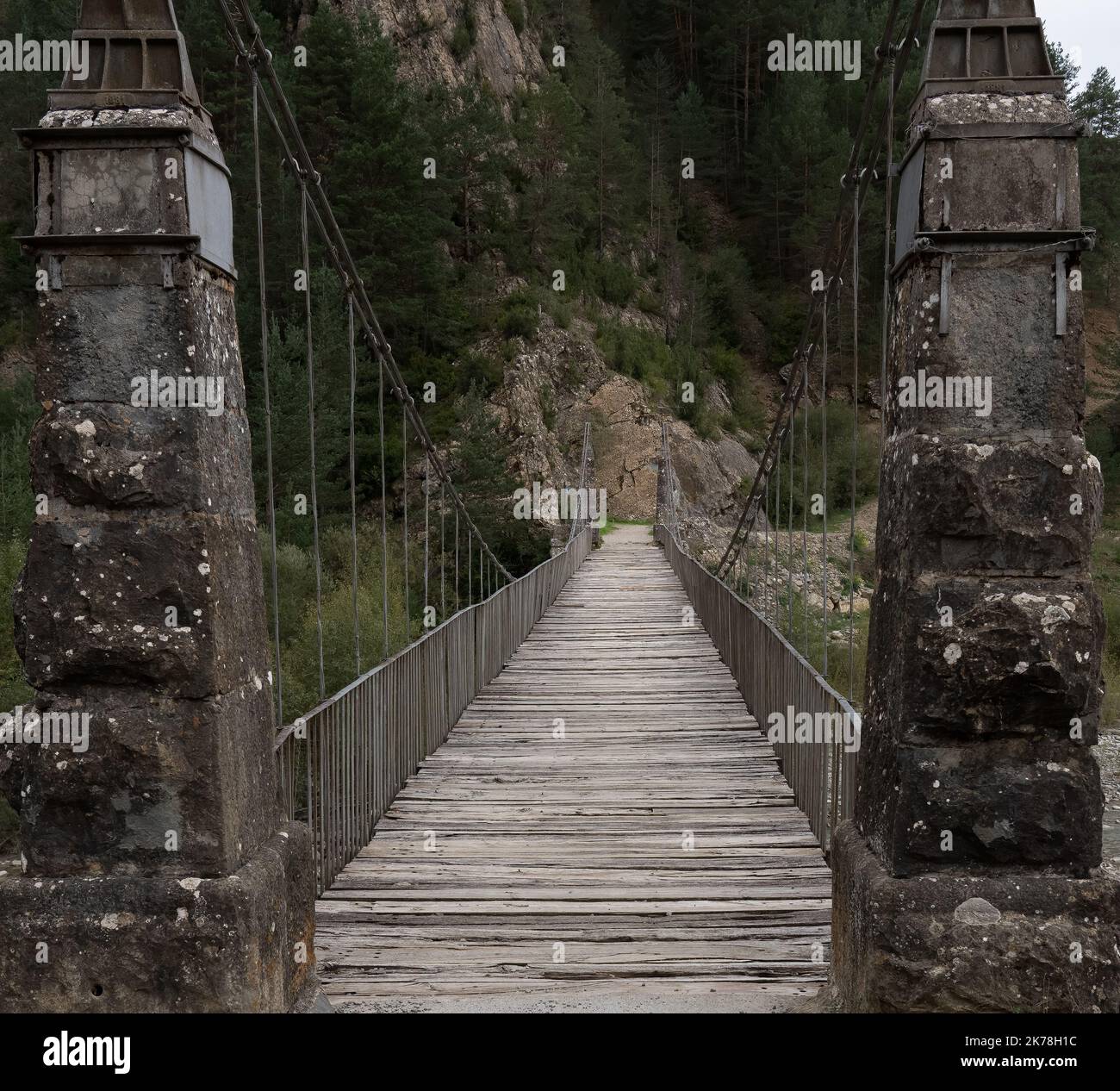 a stone pier, cable stay suspension foot bridge over a mountain river ...
