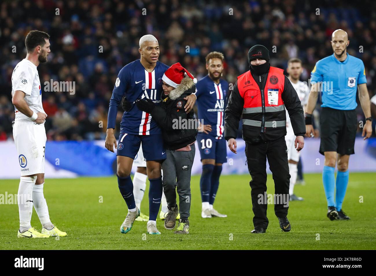 Paris Saint Germain's Kylian Mbappe hugs a young pitch invader (R ...
